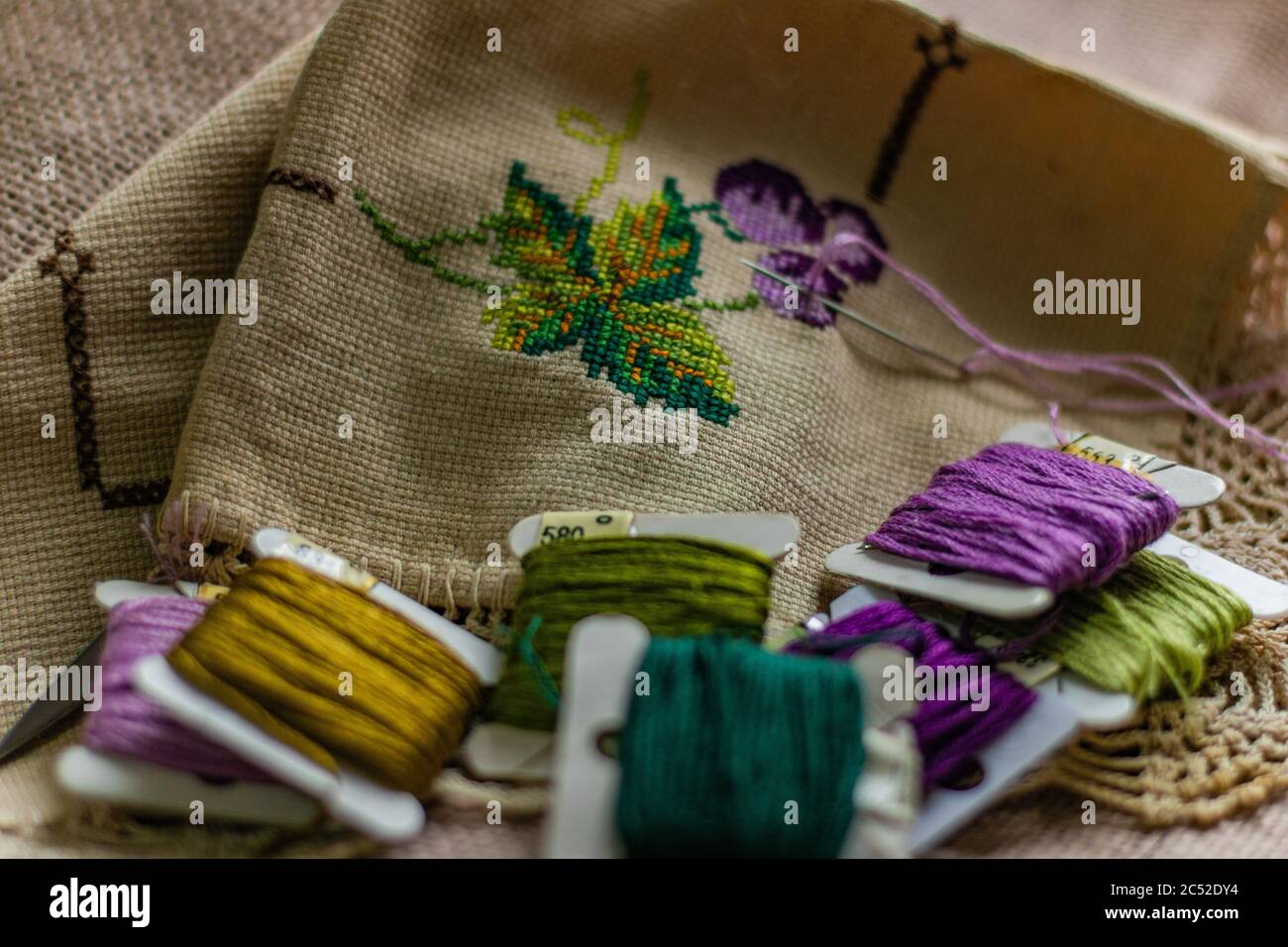 Paper spools of colorful threads and an embroidered piece of fabric ...