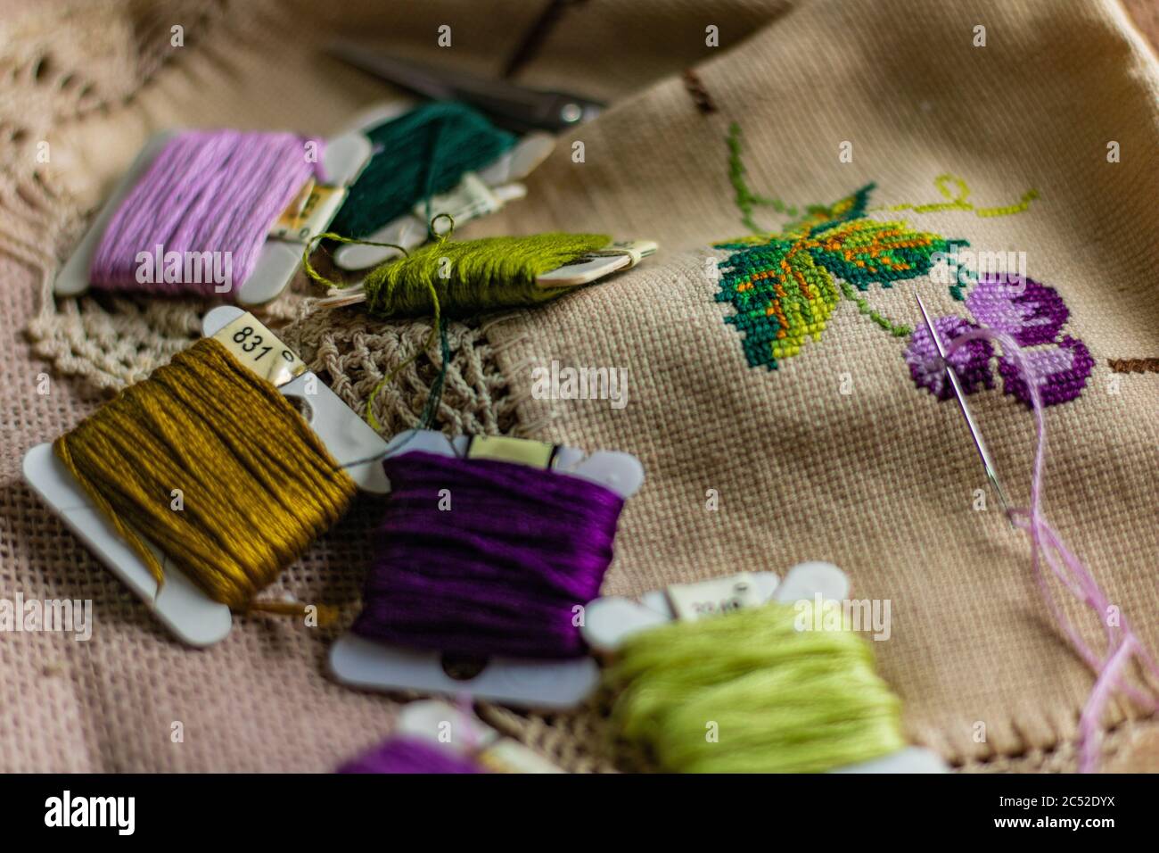 Paper spools of colorful threads and an embroidered piece of fabric ...