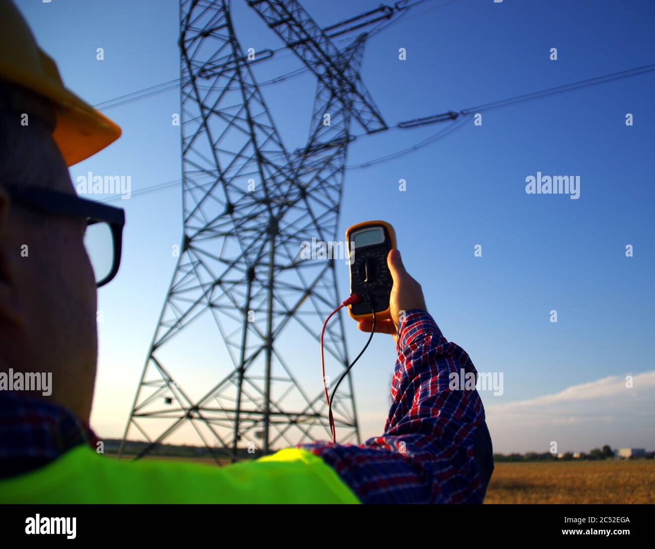 Engineer with gauge during power line infrastructure inspection ...
