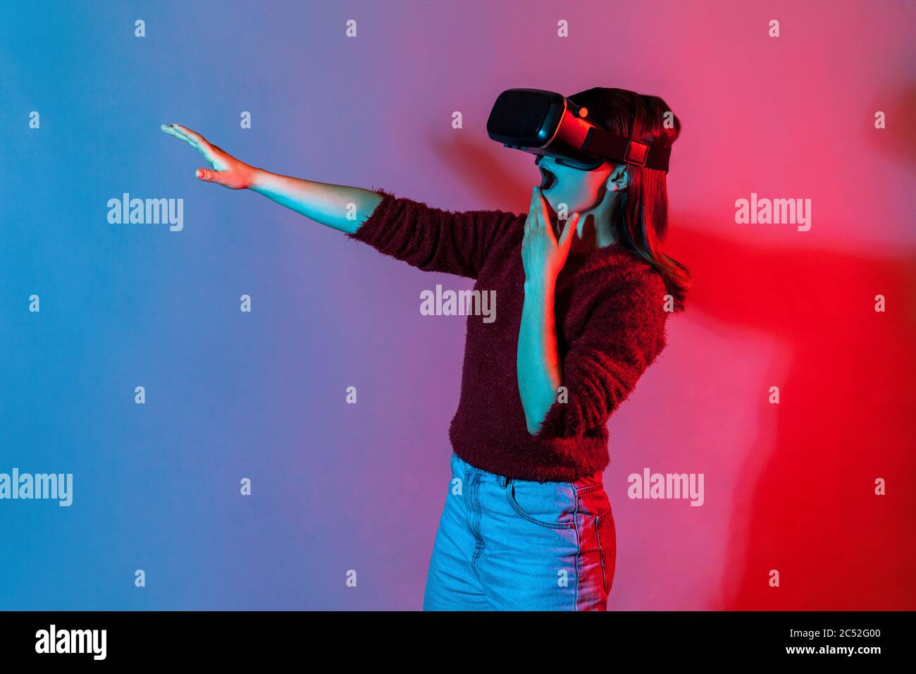 Side view, amazed girl with virtual reality glasses playing game ...