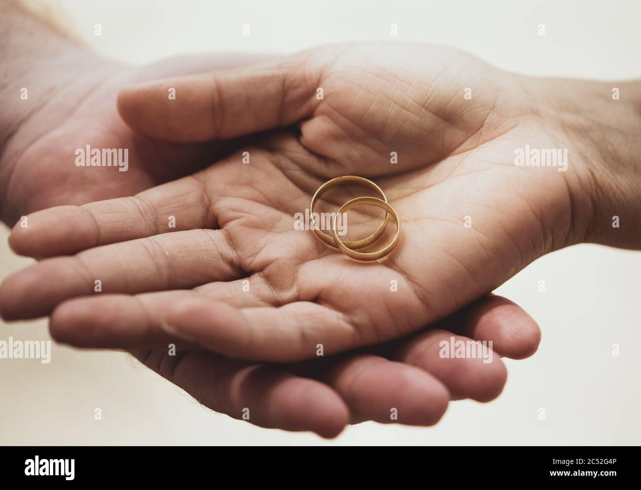 Two people holding wedding rings Stock Photo - Alamy