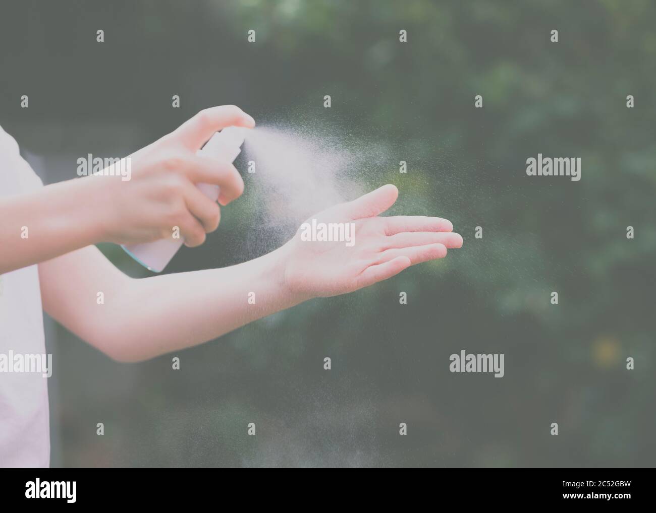 Boy spraying hand sanitser on his hand Stock Photo - Alamy