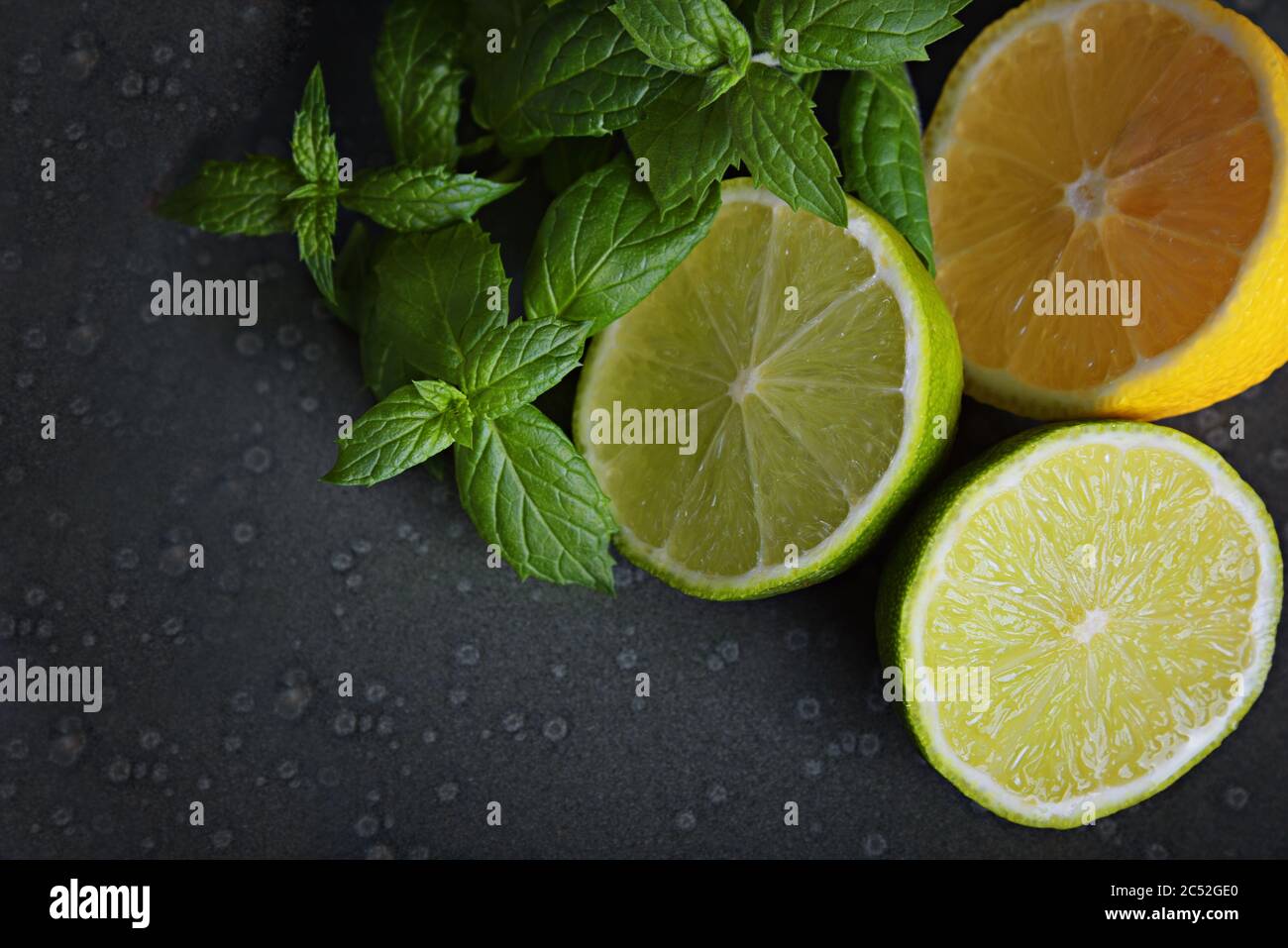 Lime, lemon and mint leaves lie on a plate on the gray background Stock ...
