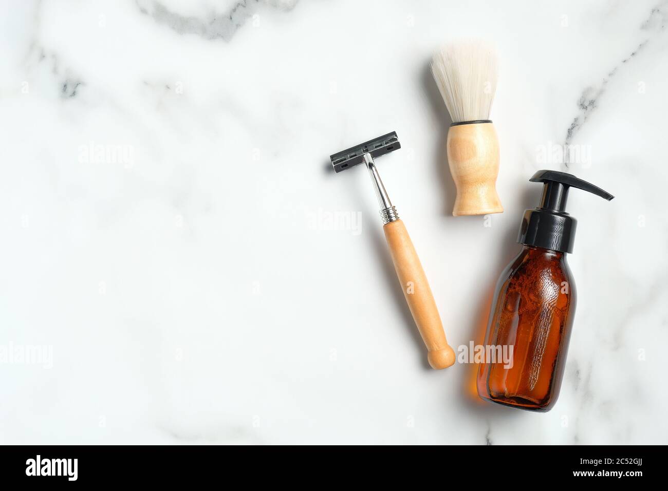 Eco-friendly shaving accessories and amber glass bottle with lotion on ...