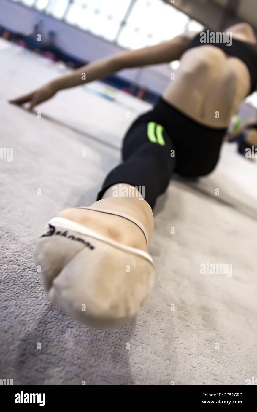 Closeup shot of a half shoe of a rhythmic gymnast doing a split during ...