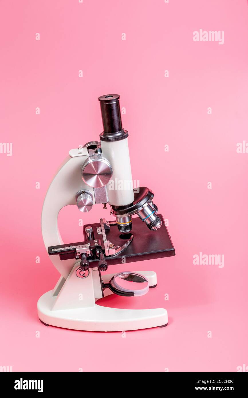 Metal microscope on pink base Stock Photo - Alamy