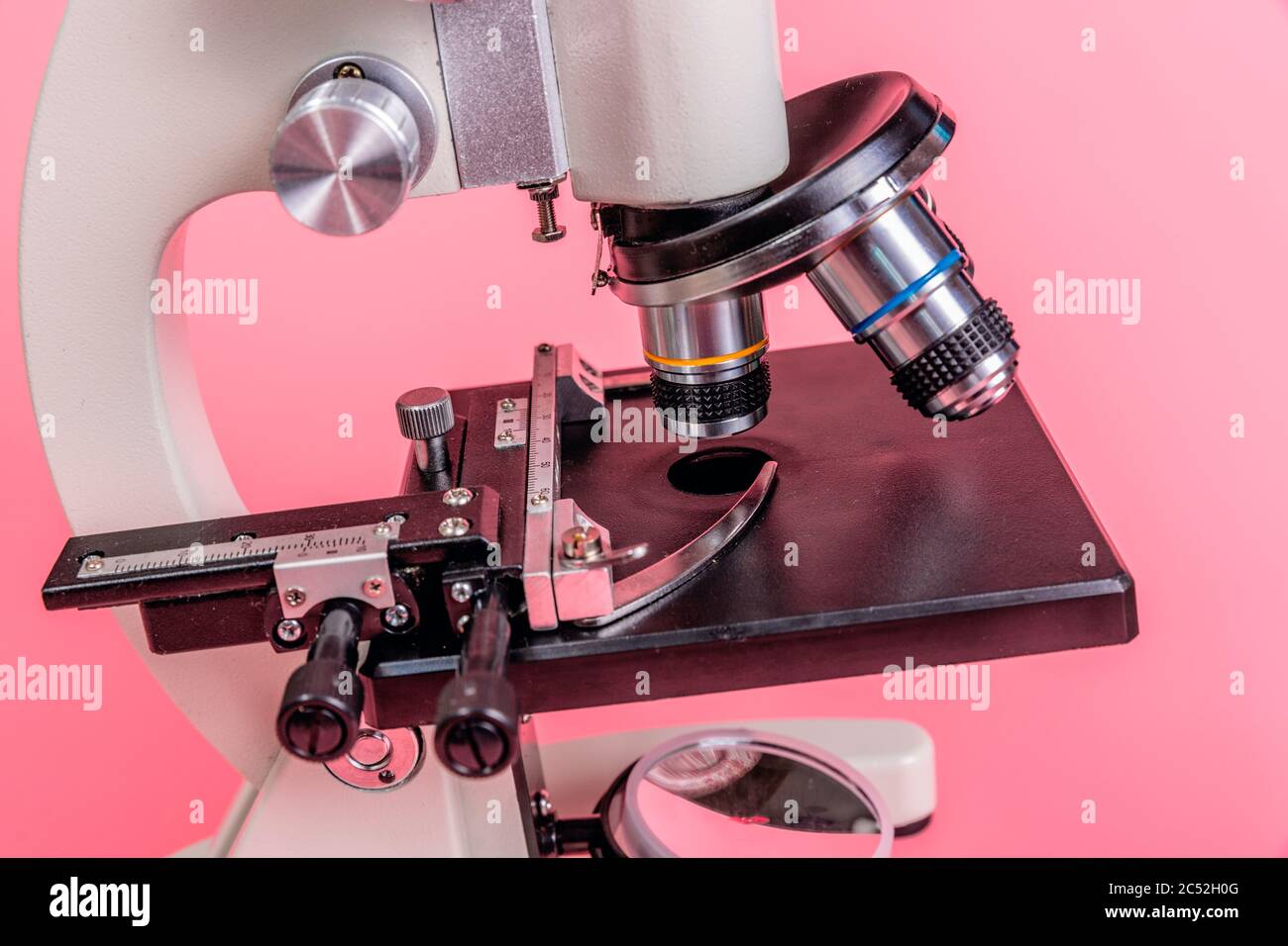 Metal microscope on pink base Stock Photo - Alamy