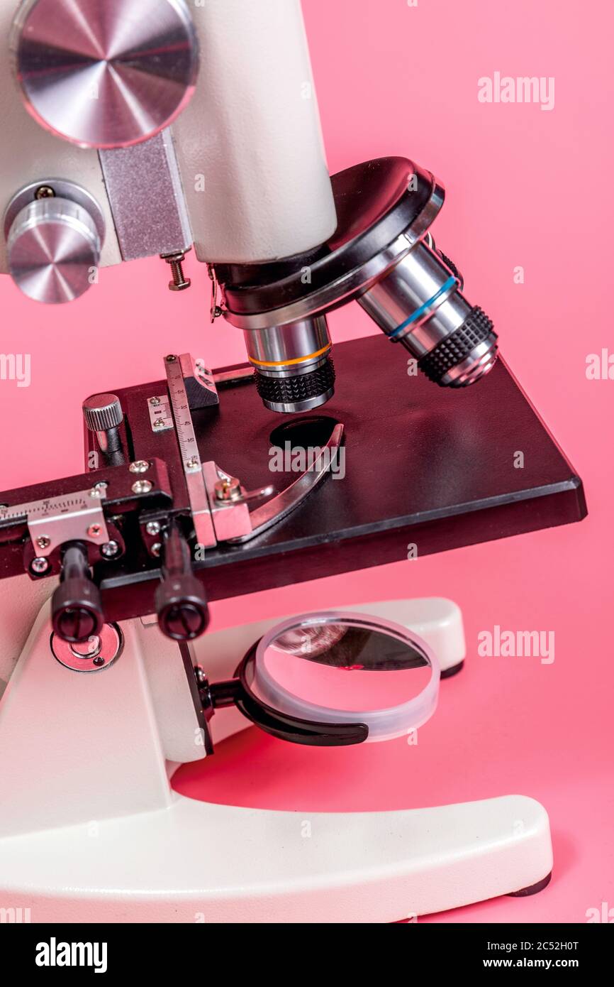 Metal microscope on pink base Stock Photo - Alamy