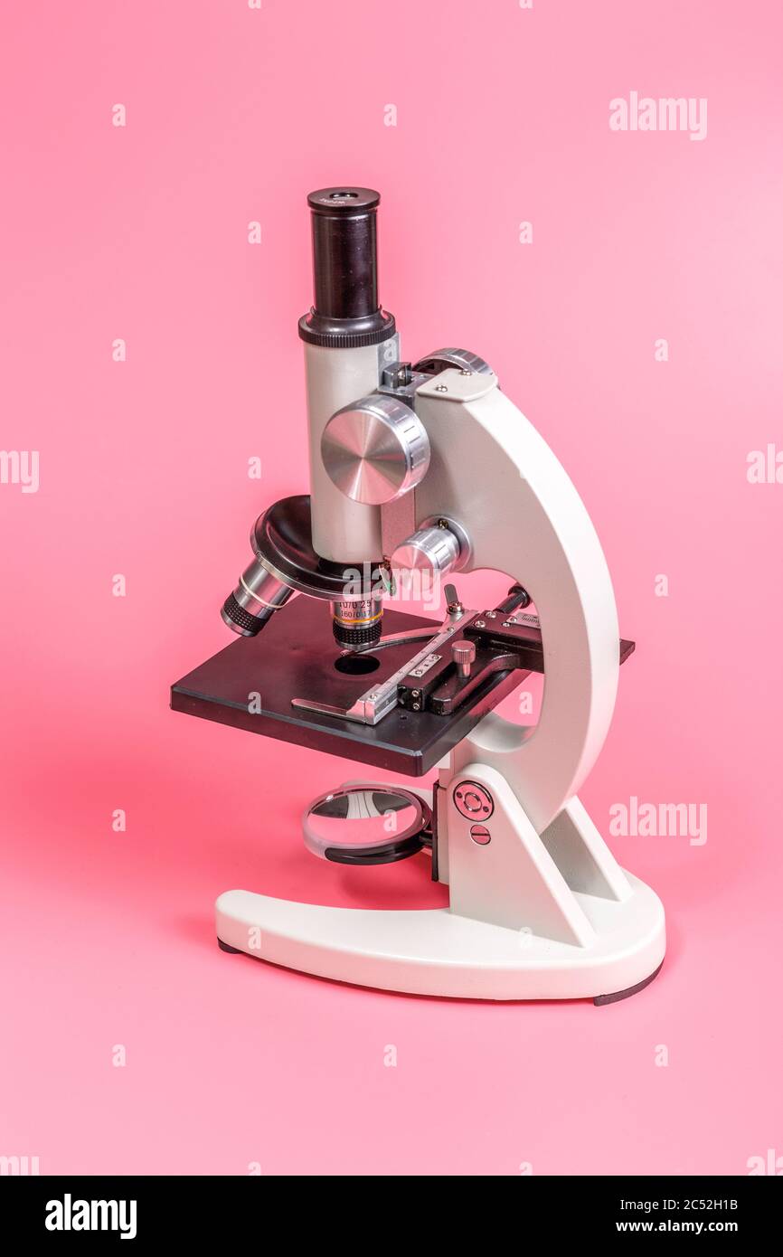 Metal microscope on pink base Stock Photo - Alamy
