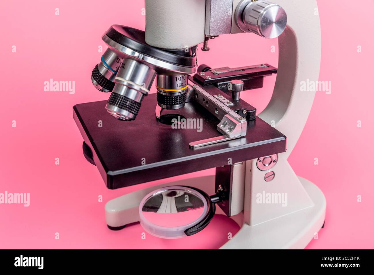 Metal microscope on pink base Stock Photo - Alamy