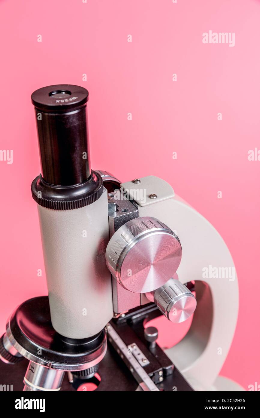Metal microscope on pink base Stock Photo - Alamy