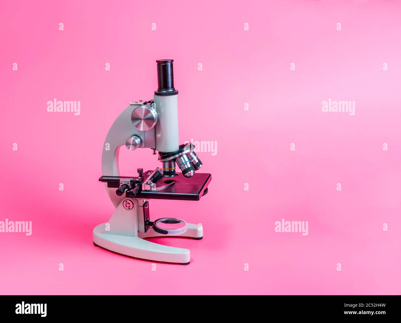 Metal microscope on pink base Stock Photo - Alamy