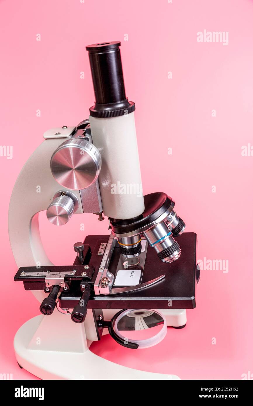 Metal microscope on pink base Stock Photo - Alamy