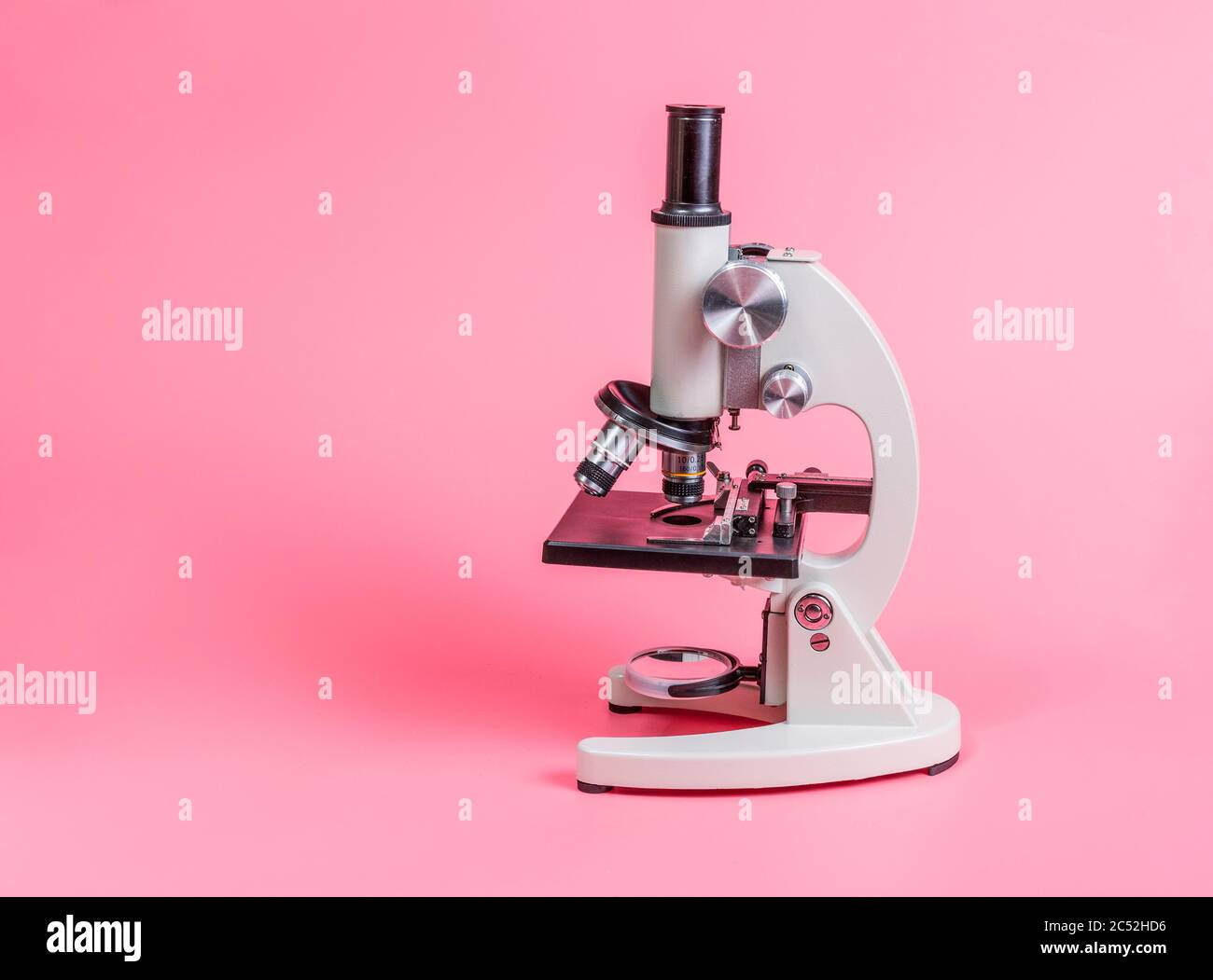 Metal microscope on pink base Stock Photo - Alamy