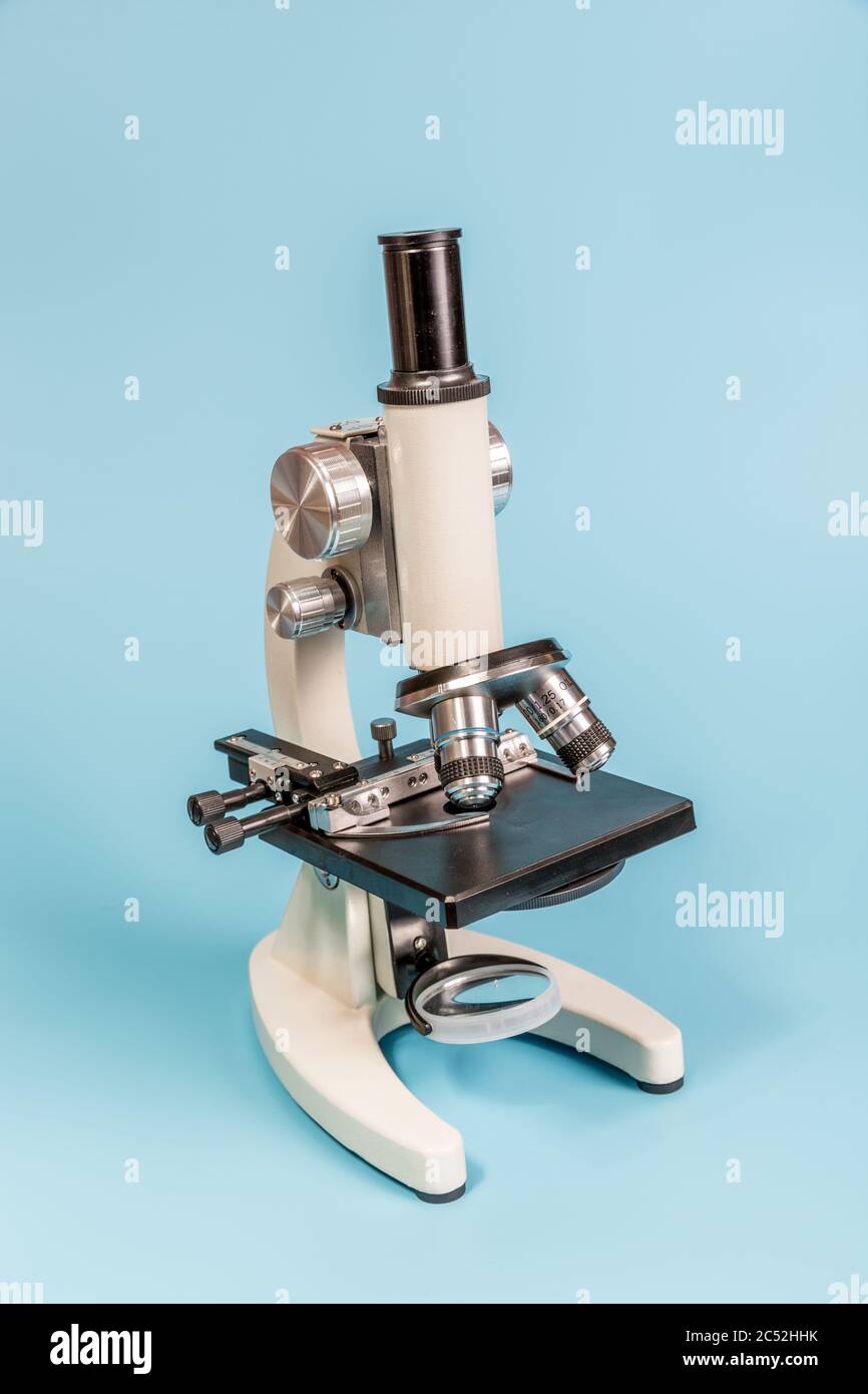 Metal microscope on blue background Stock Photo - Alamy