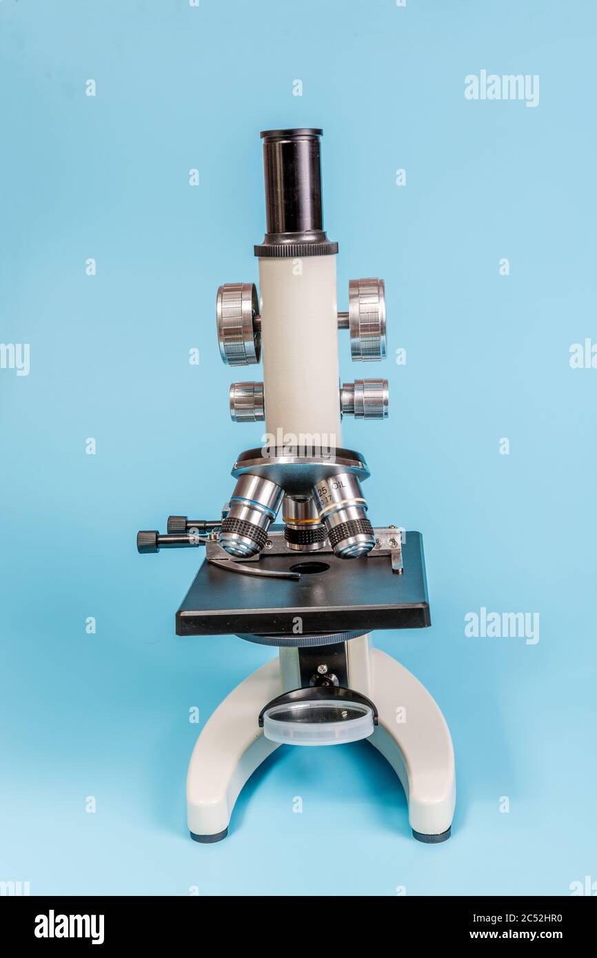 Metal microscope on blue background Stock Photo - Alamy