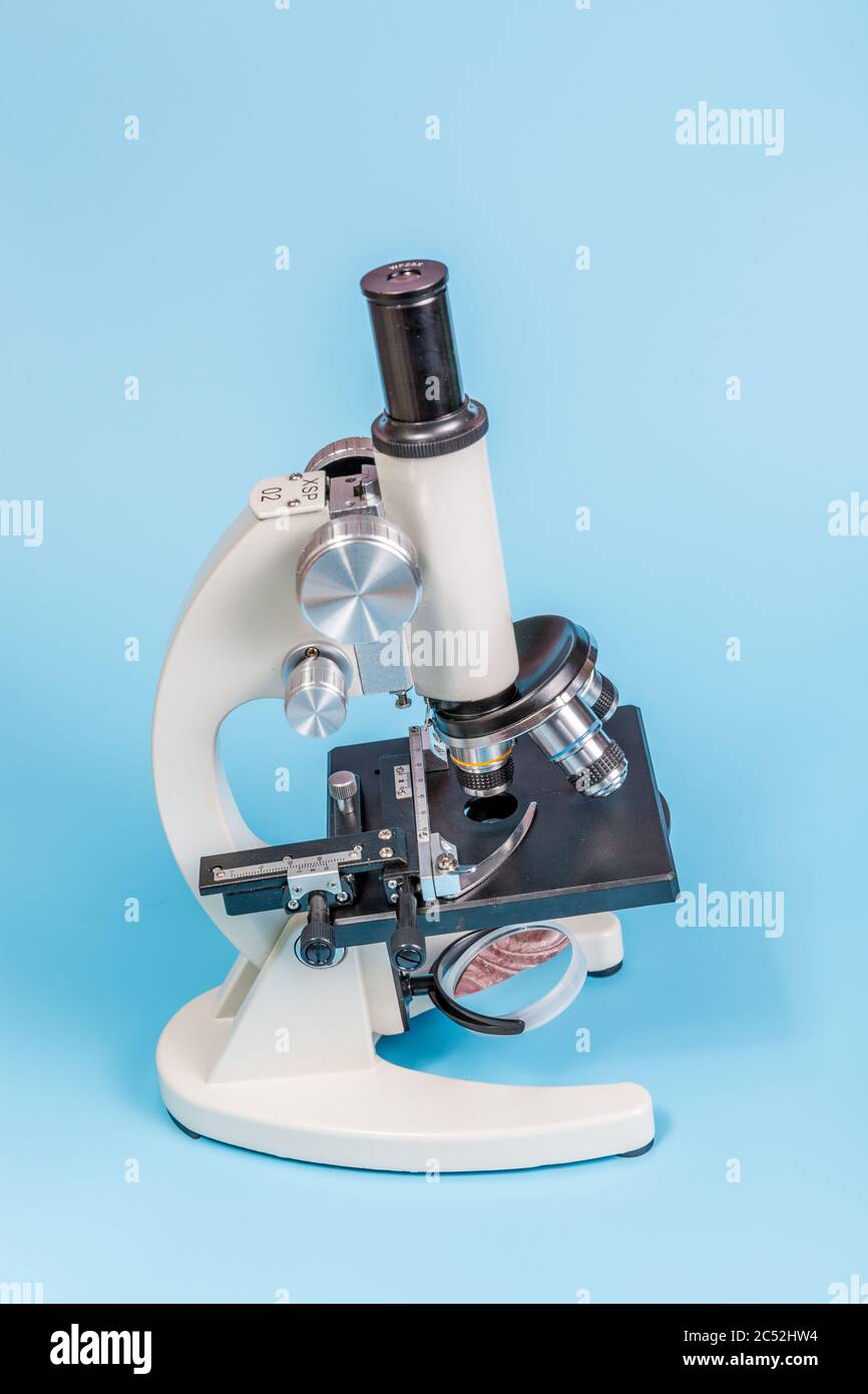 Metal microscope on blue background Stock Photo - Alamy