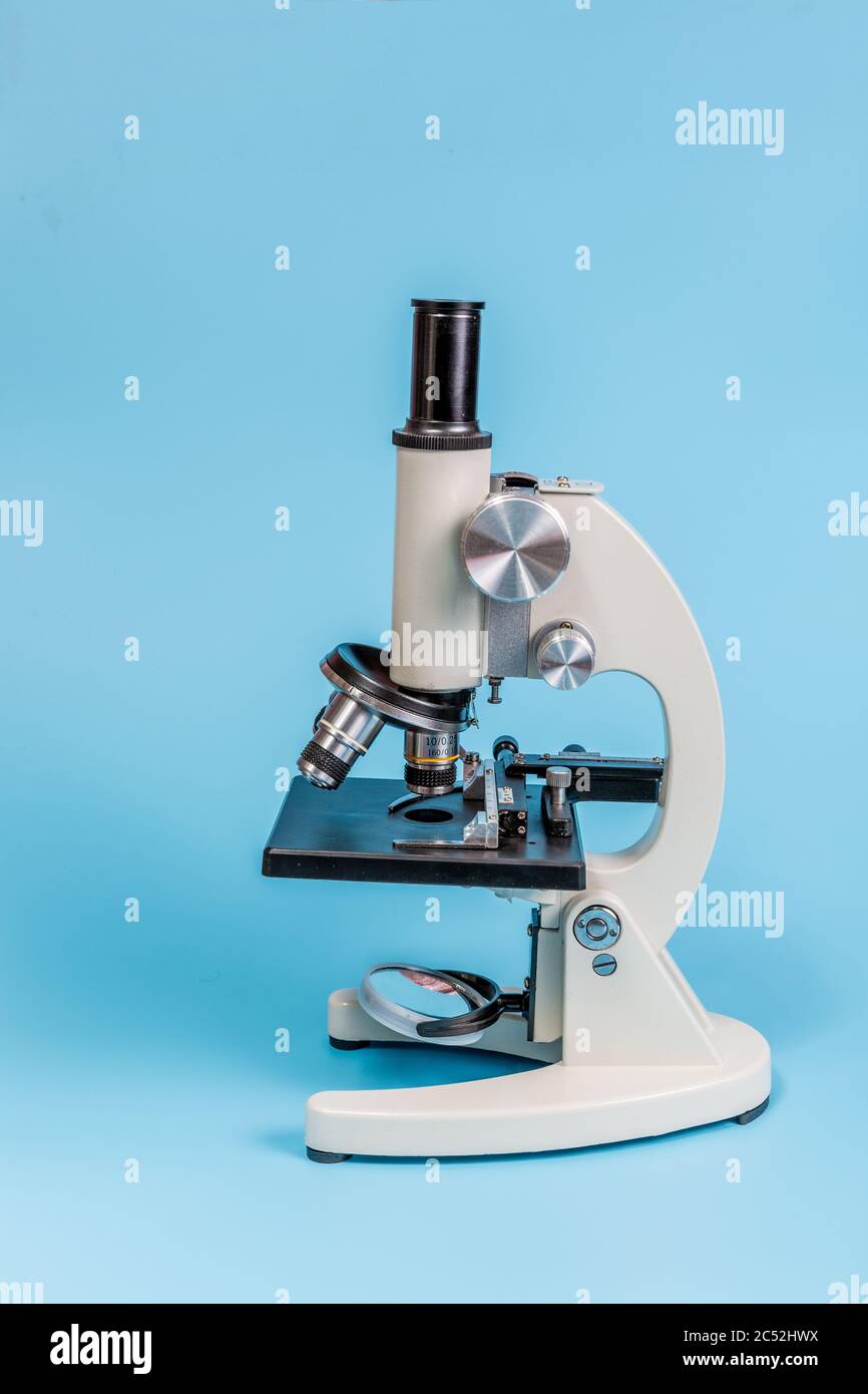 Metal microscope on blue background Stock Photo - Alamy