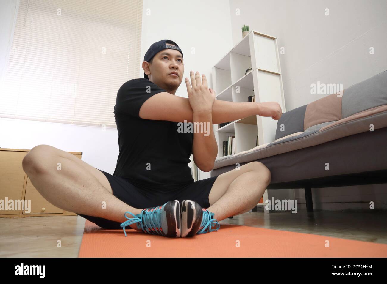 Asian male doing exercise at home to stay healthy on new normal ...
