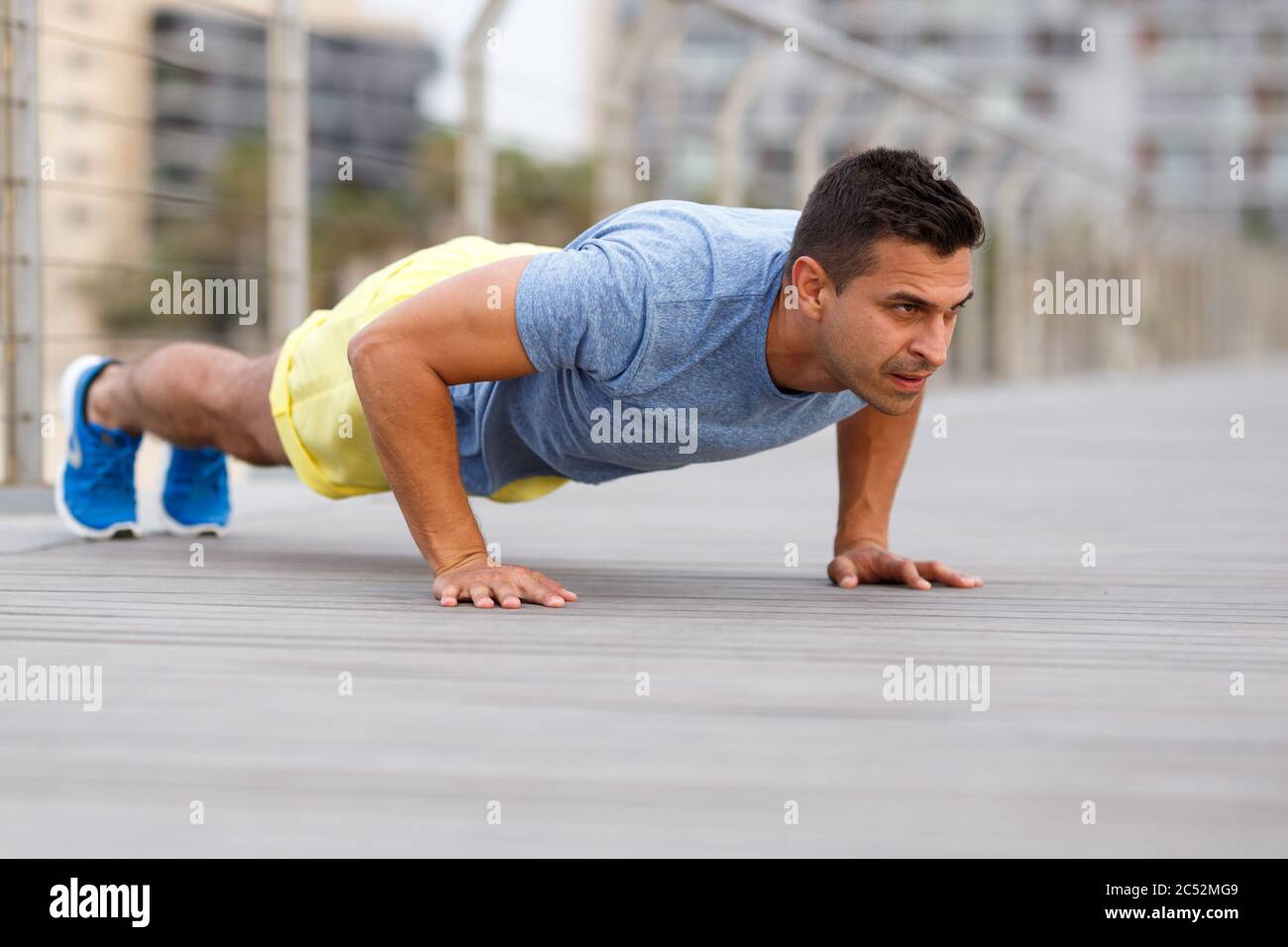 Positive male doing exercises on pier during morning workout Stock ...