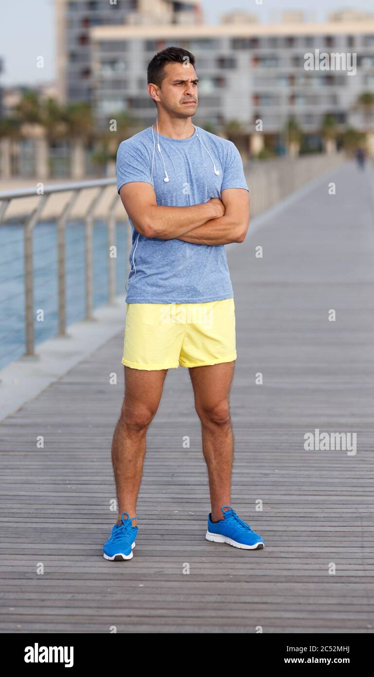 Smiling man posing after workout outdoors on urban landscape background ...