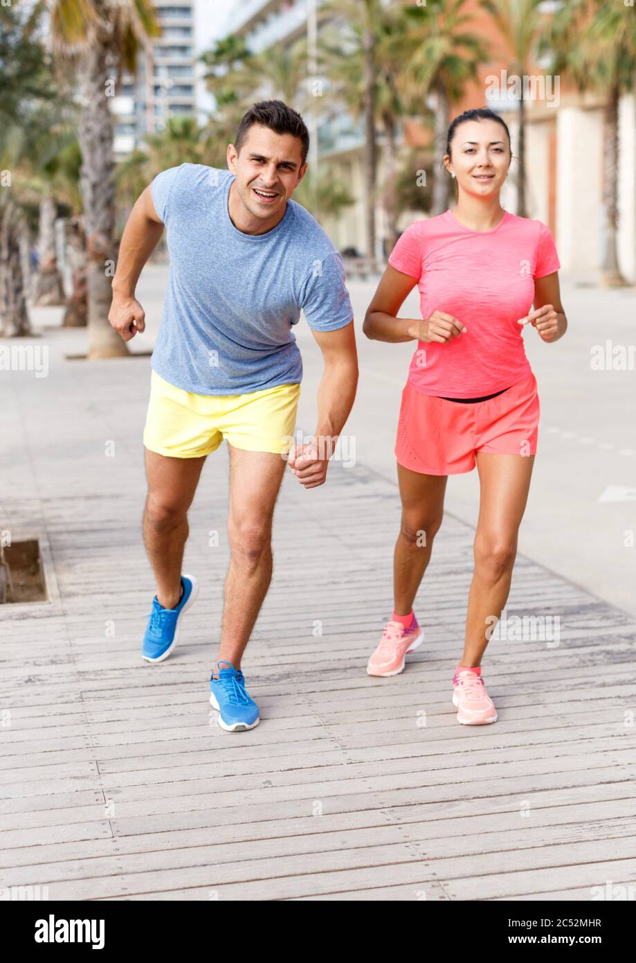 Two active friends running at morning city landscape enjoying healthy ...