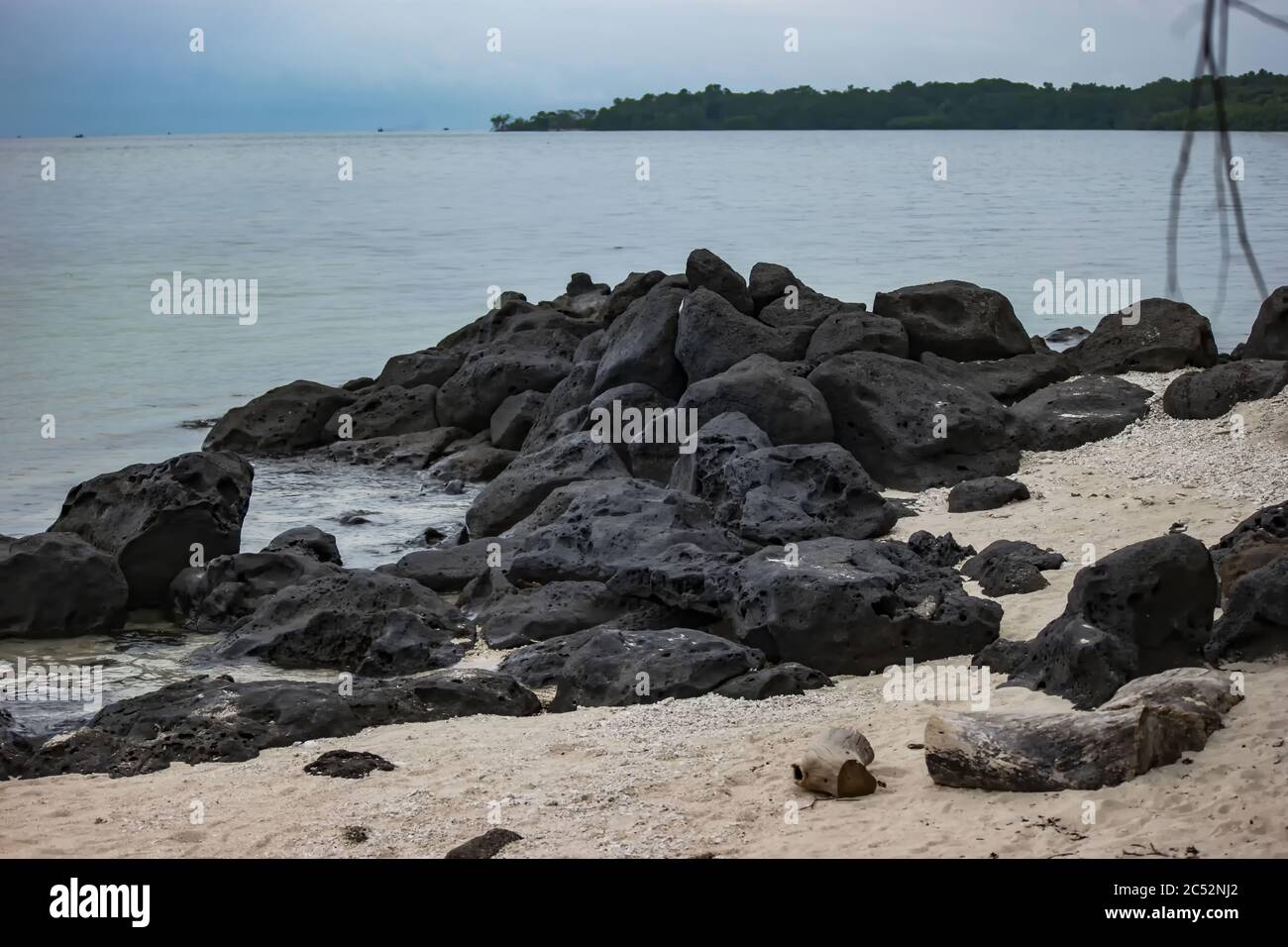 Seashore full of big black rocks - background concept Stock Photo - Alamy