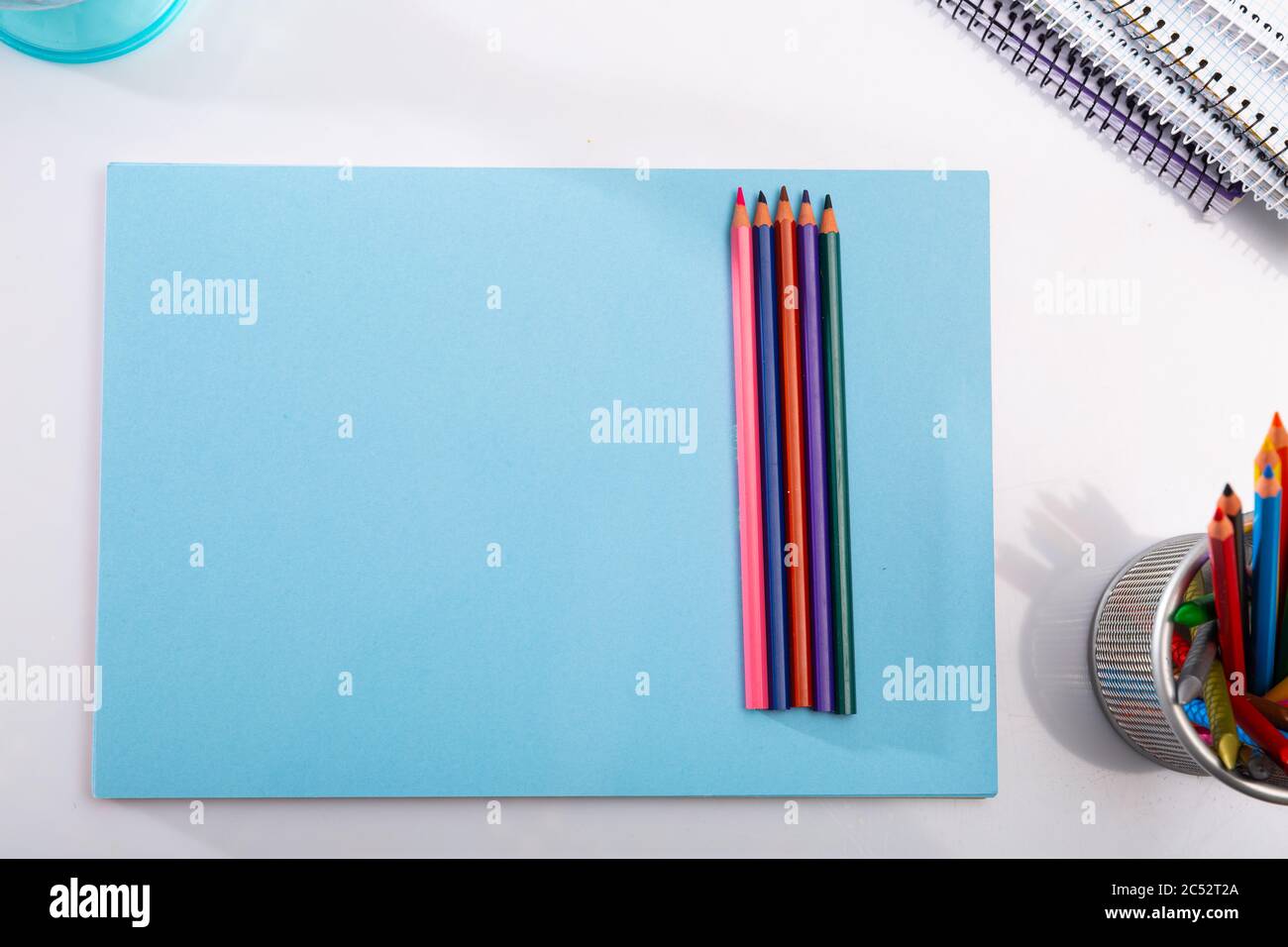 Various school stationery and blue blank paper on white background with ...