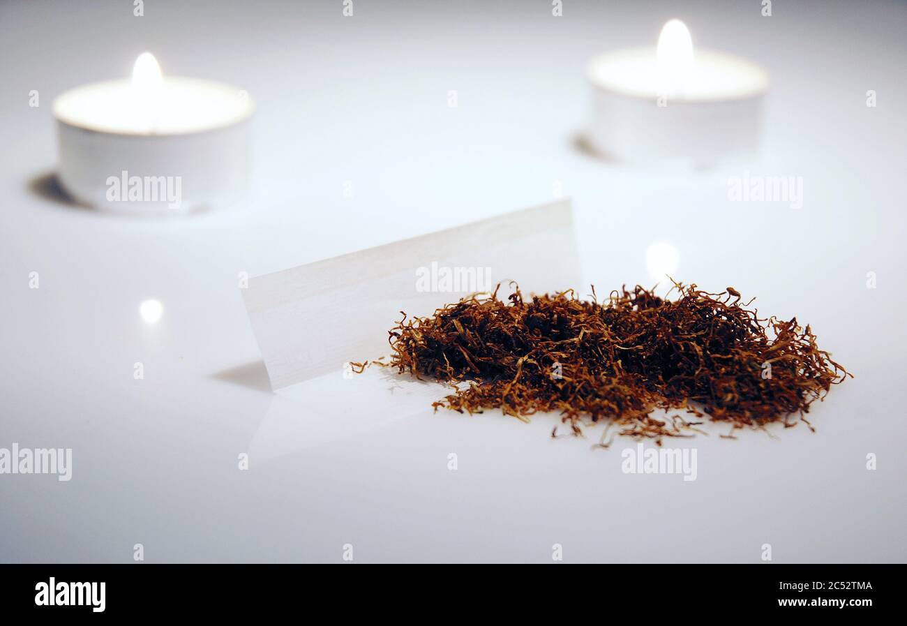 Tobacco on a table with cigarette paper and candles Stock Photo - Alamy