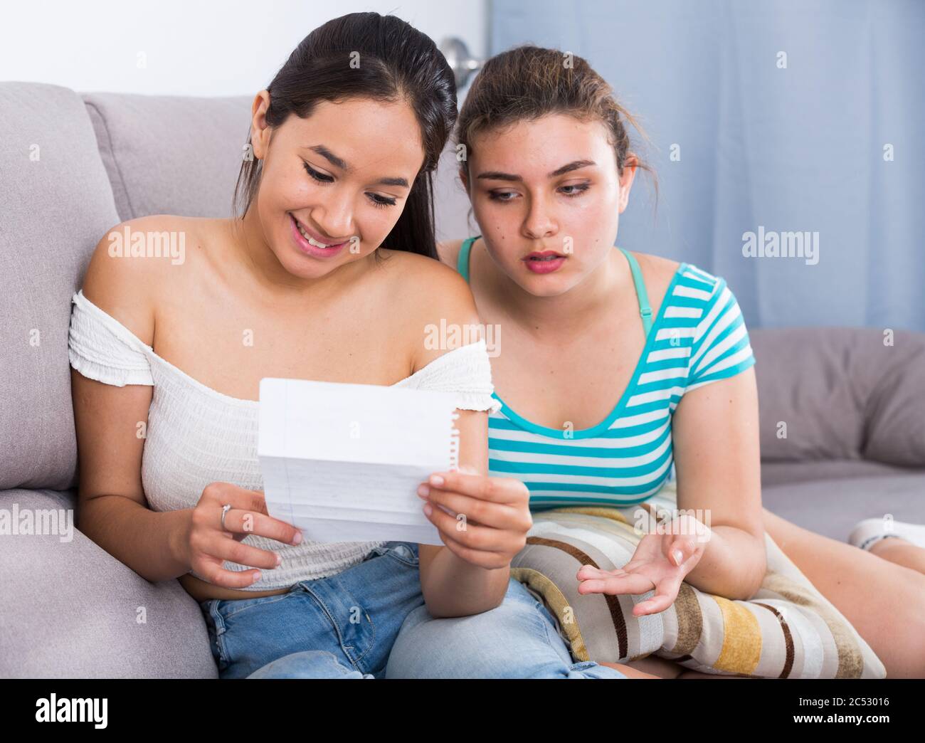 Young girl receiving love letter, reading with friend at home Stock ...