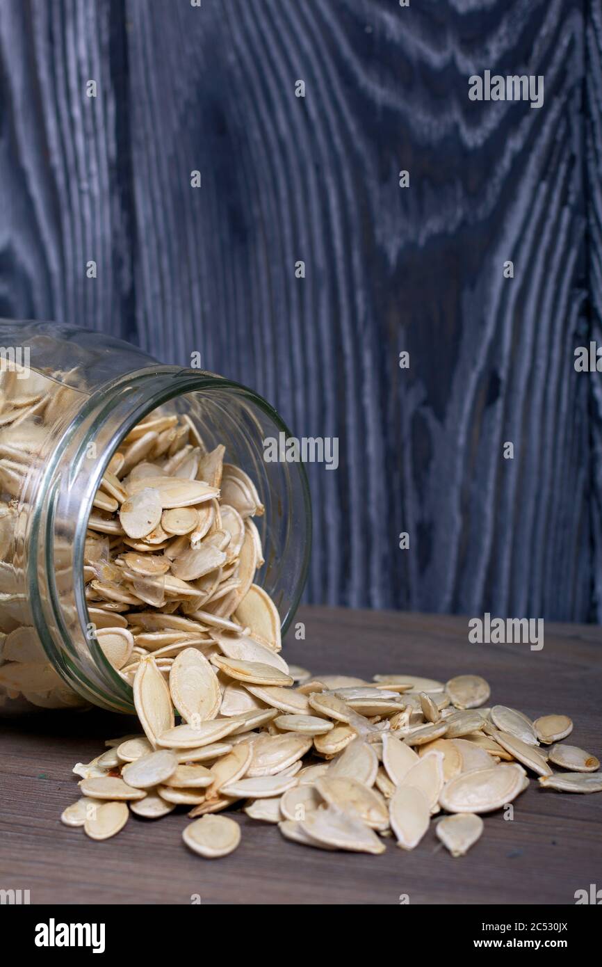 Overturned can with pumpkin seeds. A few seeds are scattered nearby ...