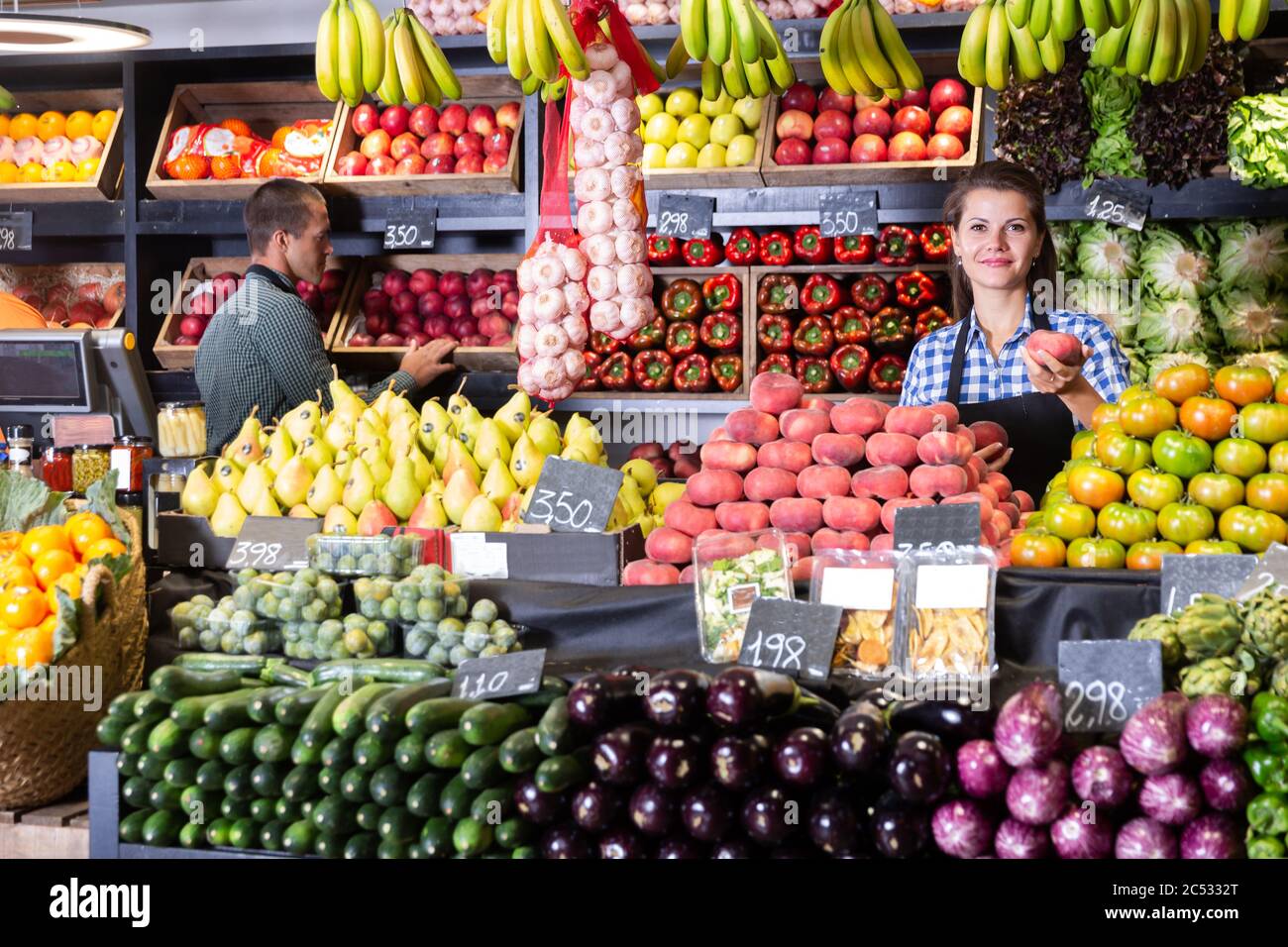 Posing nice woman and working man in fruit and vegetable shop Stock ...
