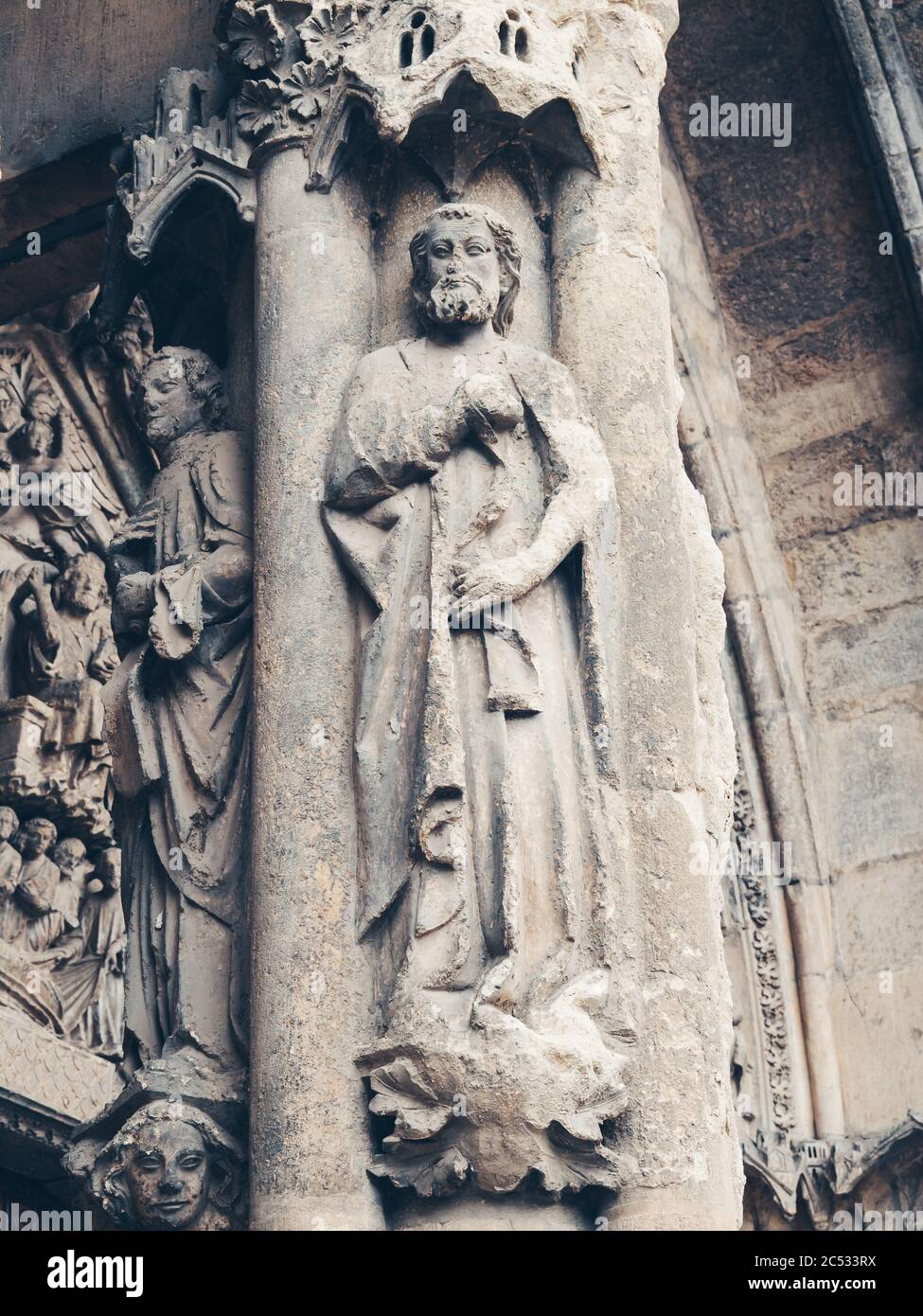 Vertical shot of statues of human figures on an exterior wall of a ...