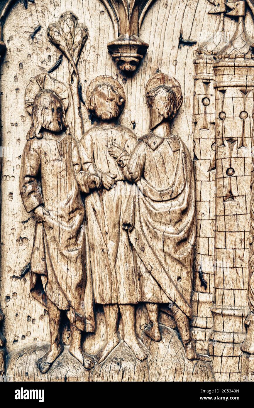 Vertical shot of statues of human figures on an exterior wall of a ...