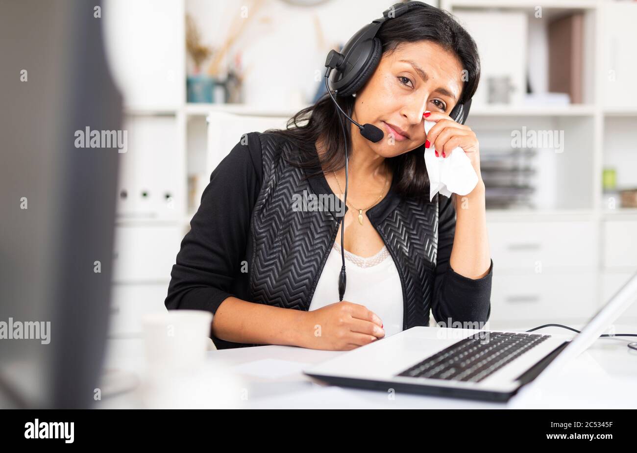 Portrait of frustrated tearful Hispanic woman customer support phone operator at workplace Stock ...