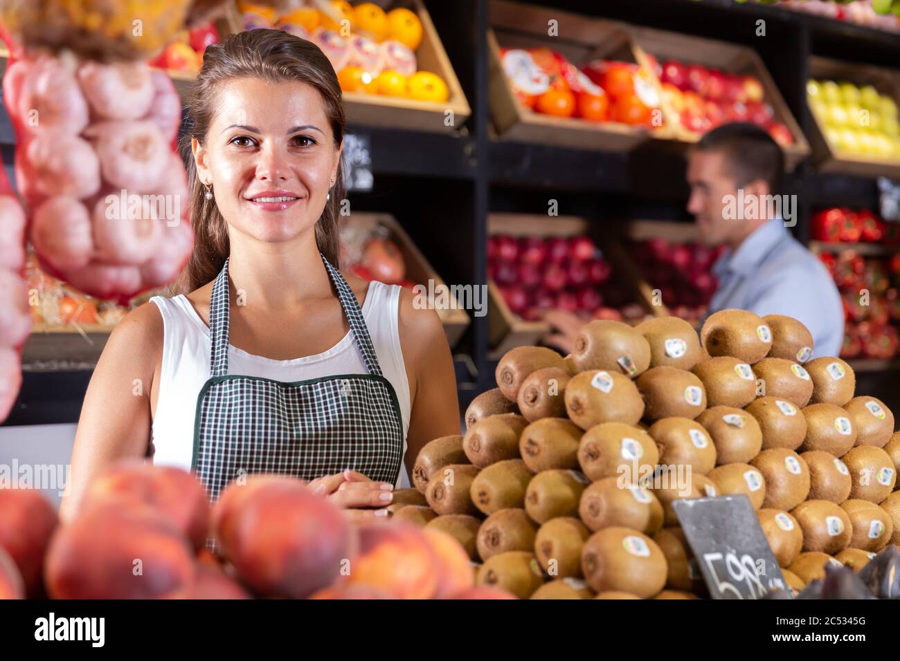 Posing positive woman and working man in fruit and vegetable shop Stock ...