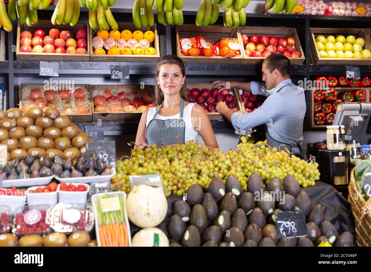 Posing friendly woman and working man in fruit and vegetable shop Stock ...