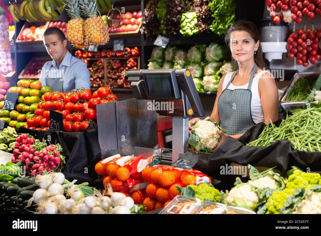 Portrait of diligent positive smiling female and male vegetable shop ...