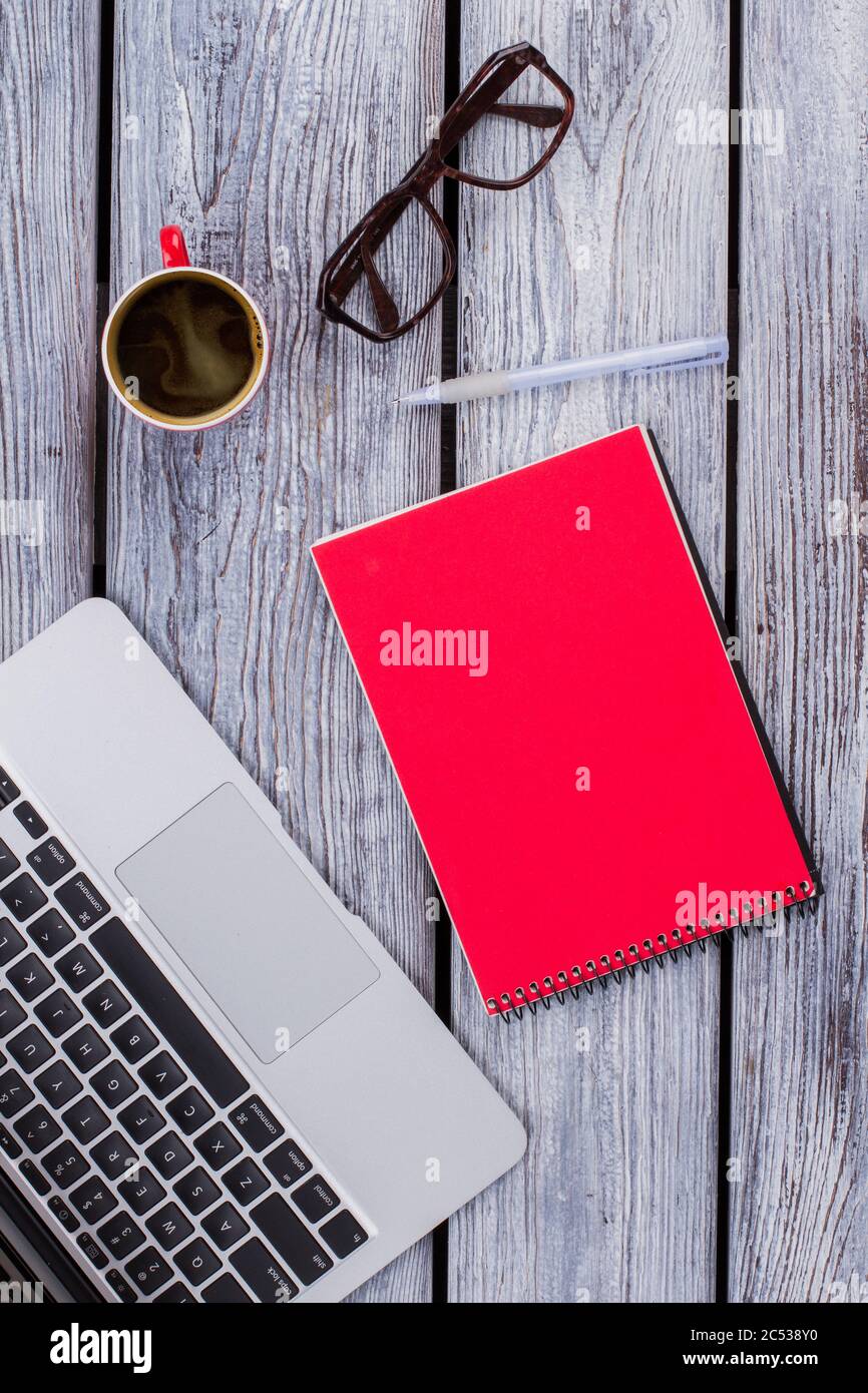 Red notepad with laptop and glasses Stock Photo - Alamy