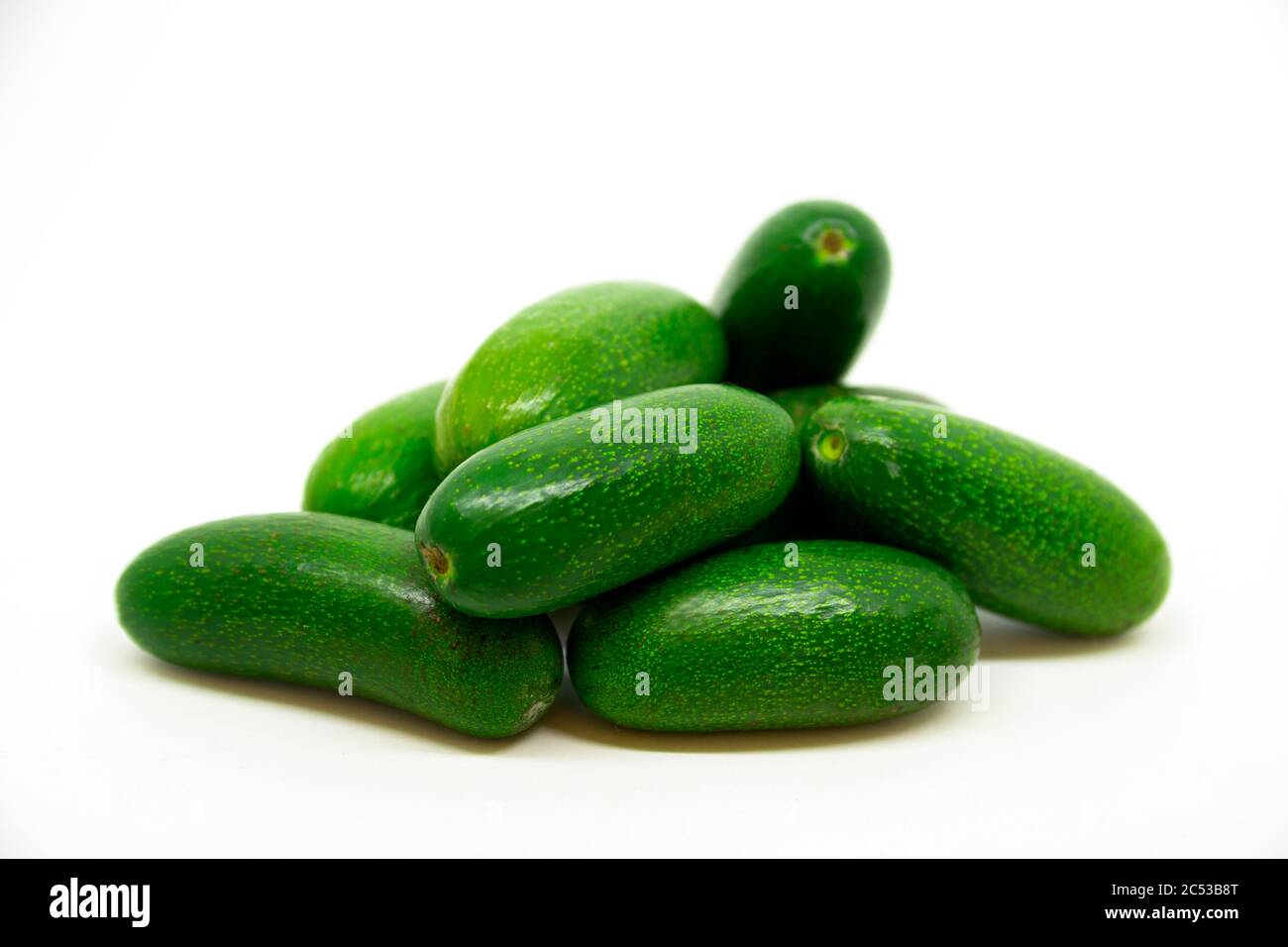 Mini avocados on white background Stock Photo - Alamy