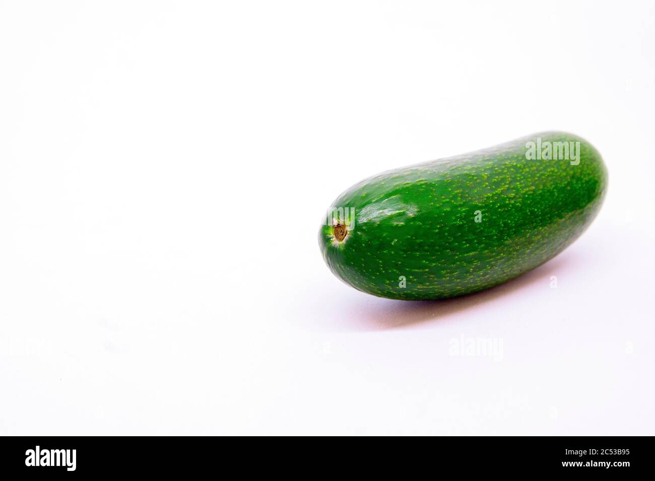 Mini avocados on white background Stock Photo - Alamy