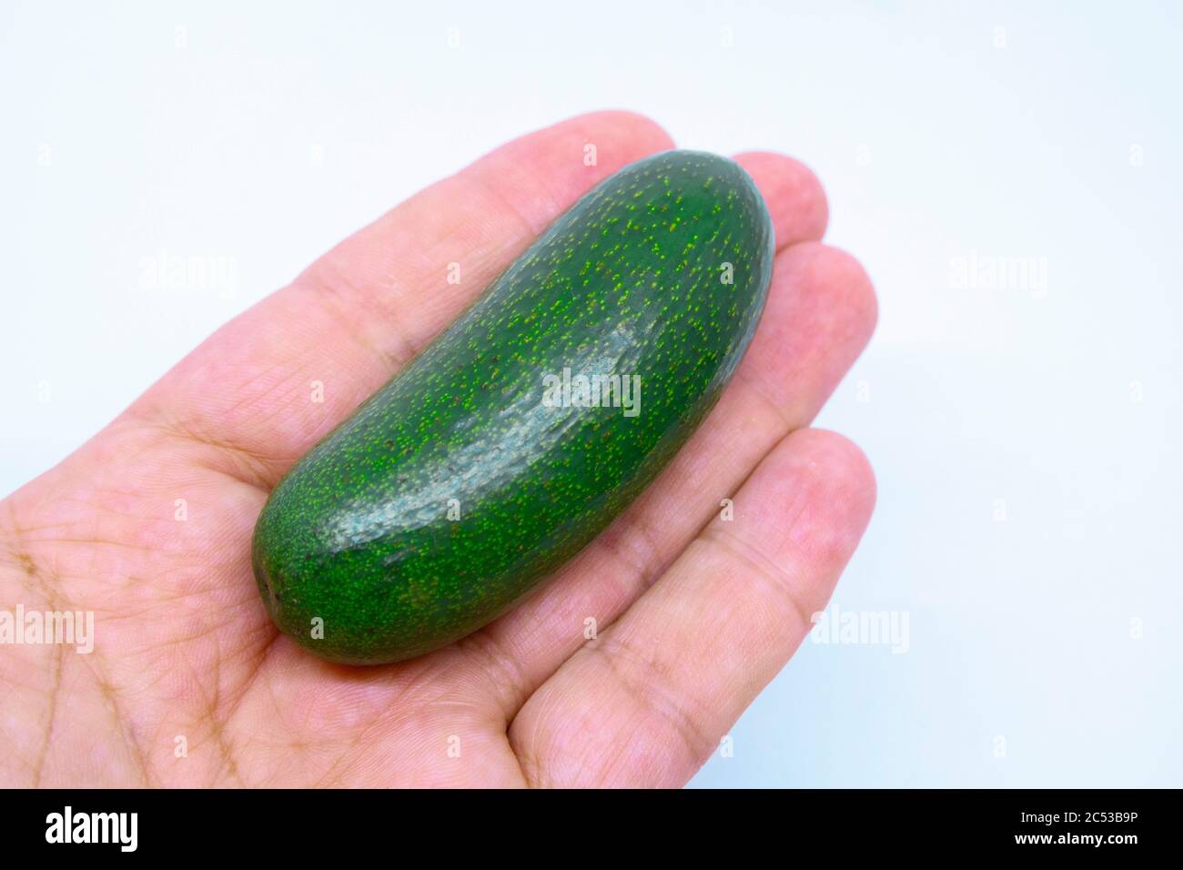 Mini avocados on white background Stock Photo - Alamy