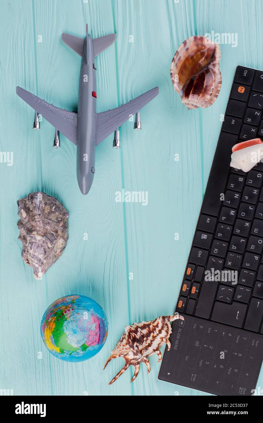 Minimal simple flat lay with plane globe and seashells on blue pastel ...