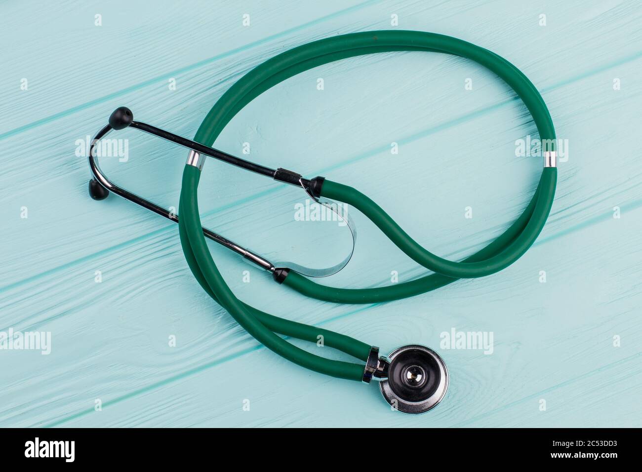 Green stethoscope on turquoise background Stock Photo - Alamy