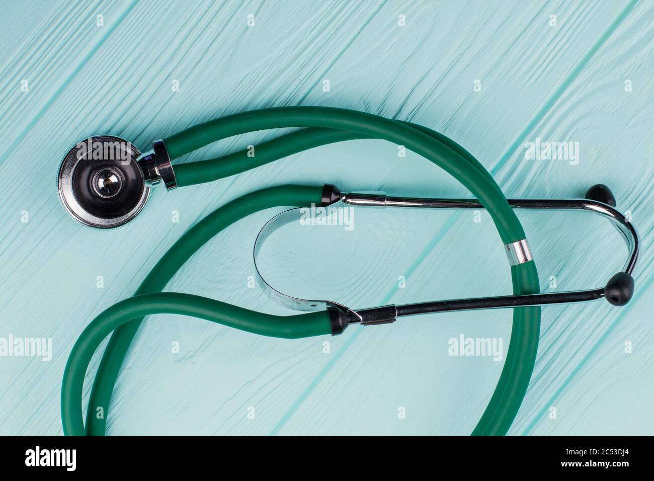 Green stethoscope on turquoise background Stock Photo - Alamy