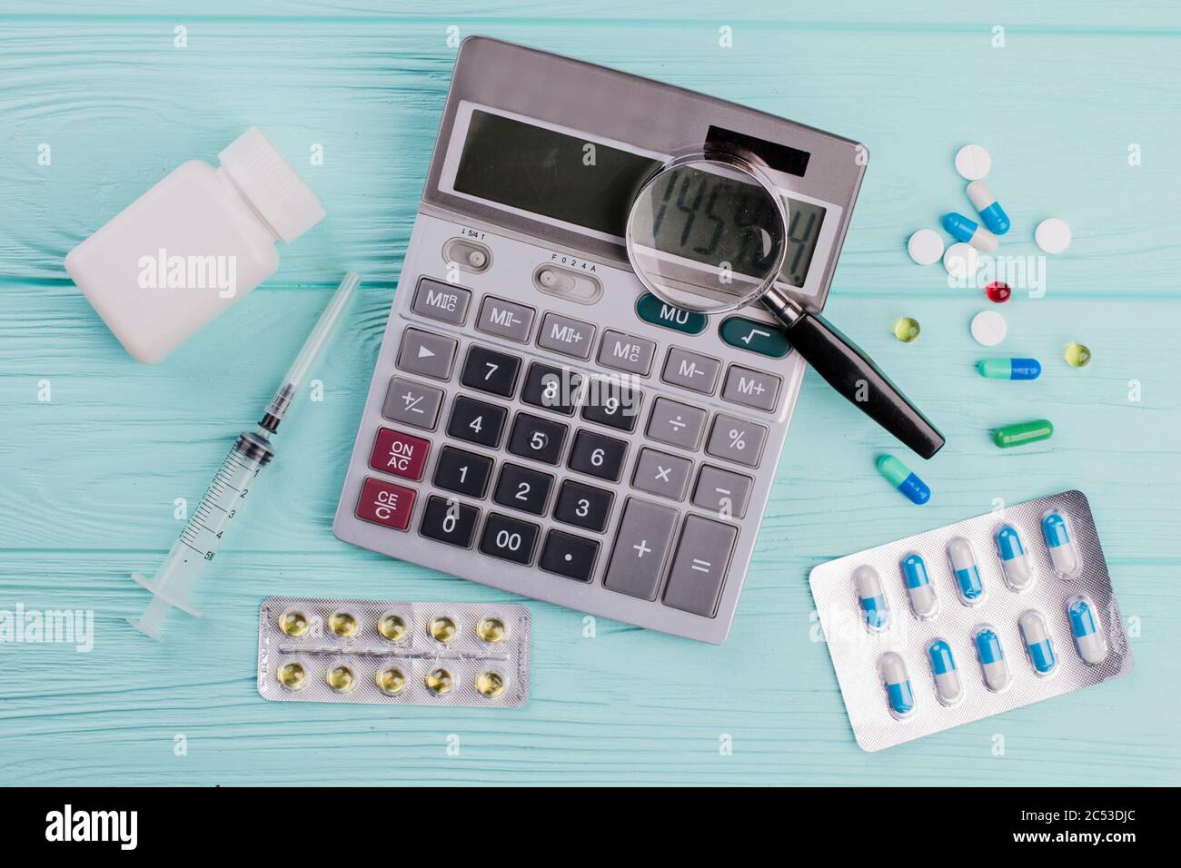 Stethoscope and magnifier over a calculator symbol for health care ...