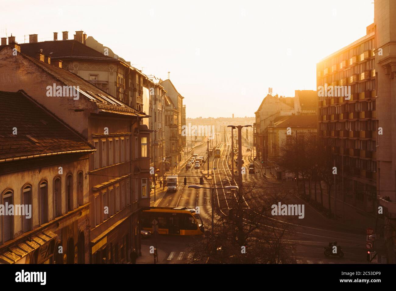Street of Budapest city with morning rush during the orange sunrise ...