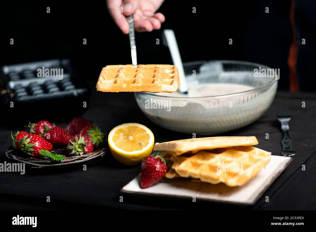 Man making waffles on a waffle machine close up Stock Photo - Alamy