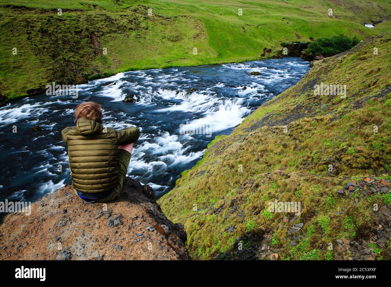 Iceland, man sitting on a river Stock Photo - Alamy