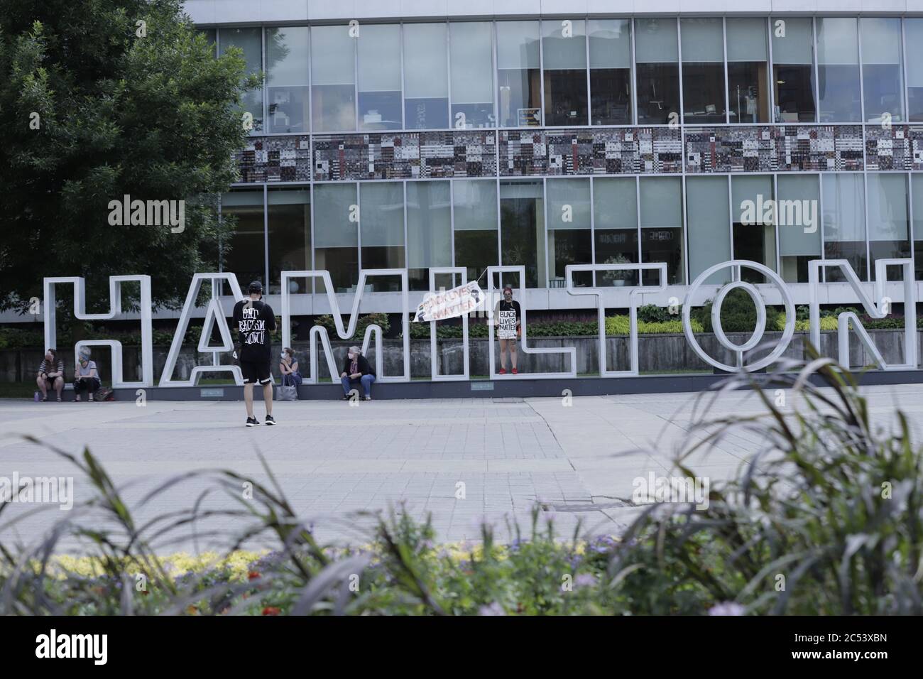 People gather around Hamilton city sign for peaceful anti racism ...